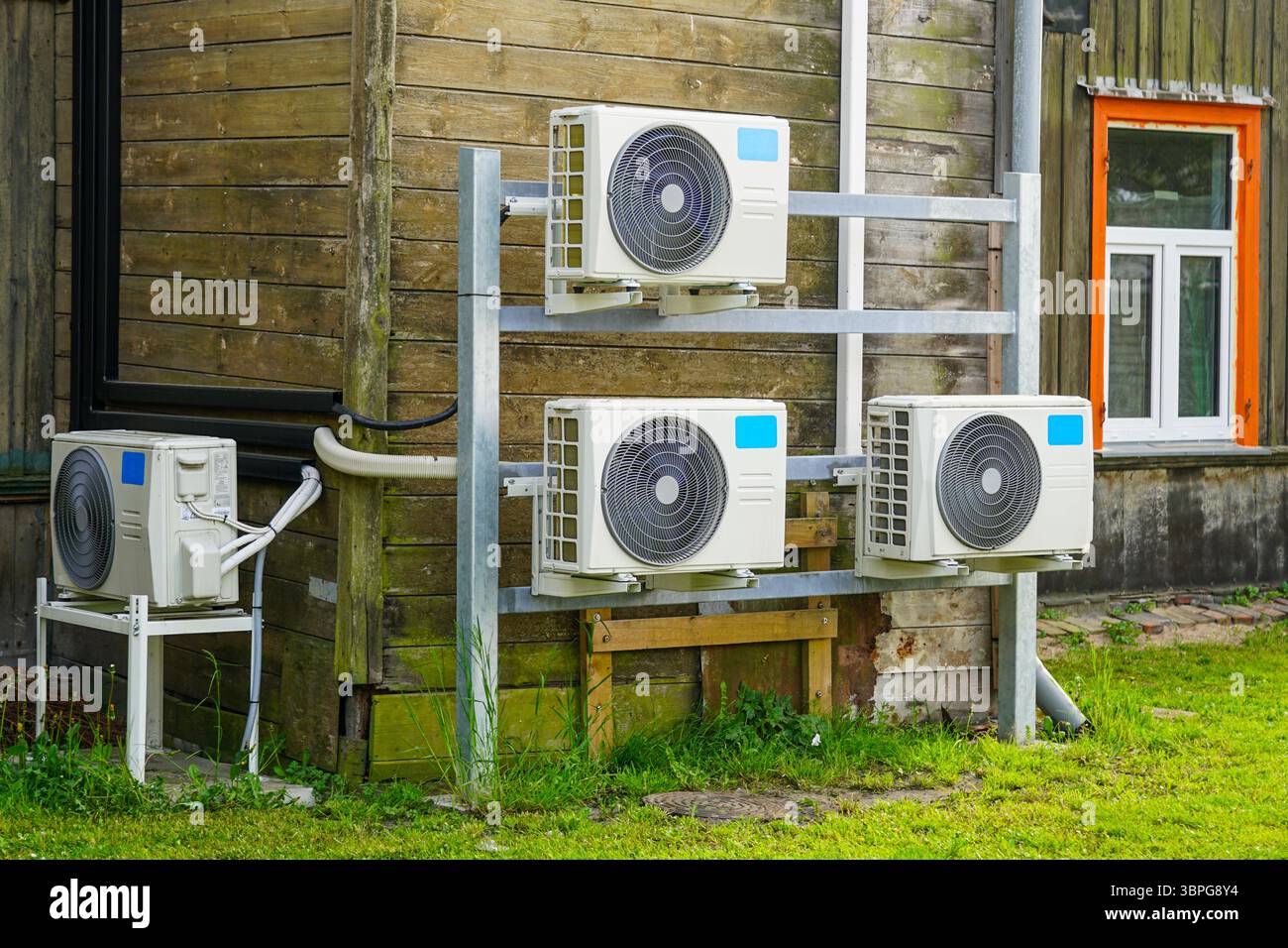 Multiple Air-to-Air Heat Pump Outdoor Units Installed on Wooden Wall of ...