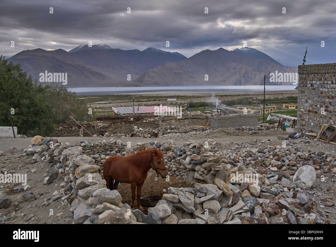 A house stands inside a stone-walled enclosure on an early morning in ...