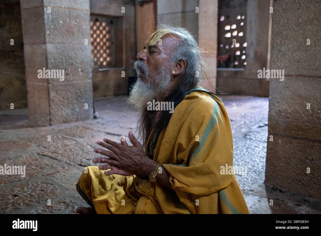 Hindu priest Susanta Baba chants and plays finger cymbals in the ...