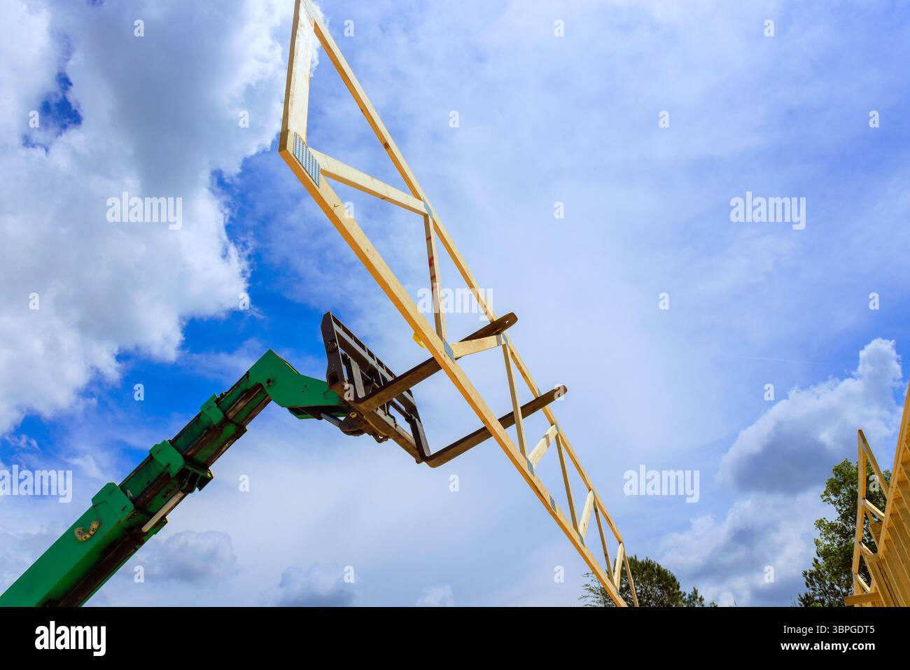 Forklift telehandler machinery raises wooden trusses beams high in air ...