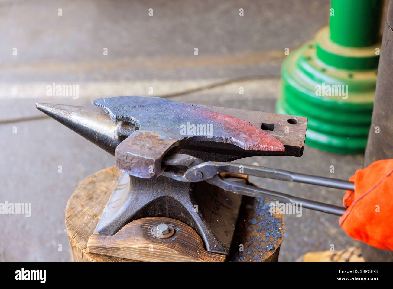 Skilled blacksmith uses tongs to manipulate hot metal on an anvil in ...