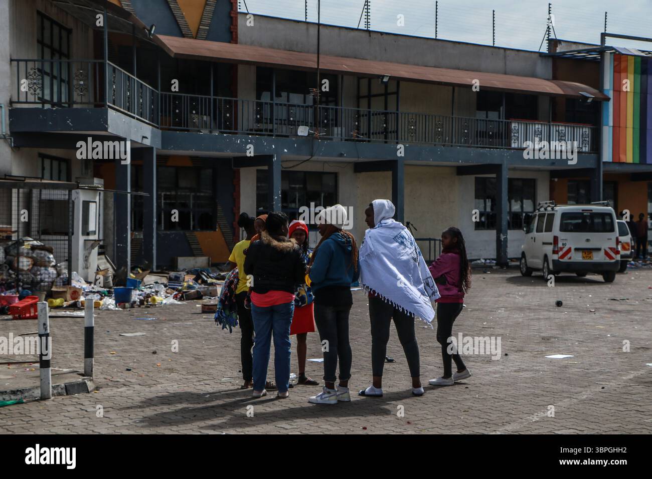 Workers gather outside their shops following looting by criminals who ...