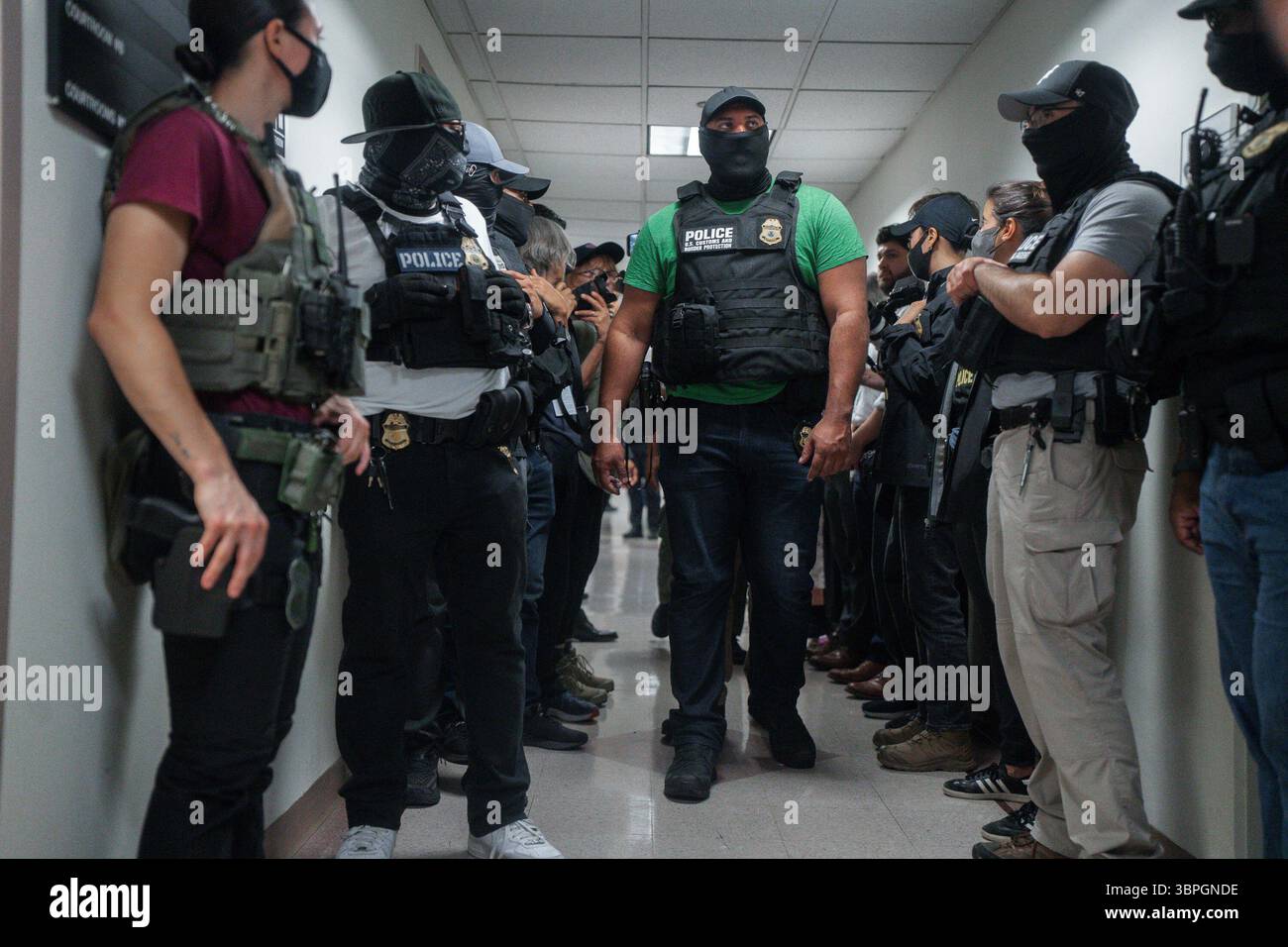 Masked federal agents wait outside an immigration courtroom on Tuesday, July 8, 2025, in New ...