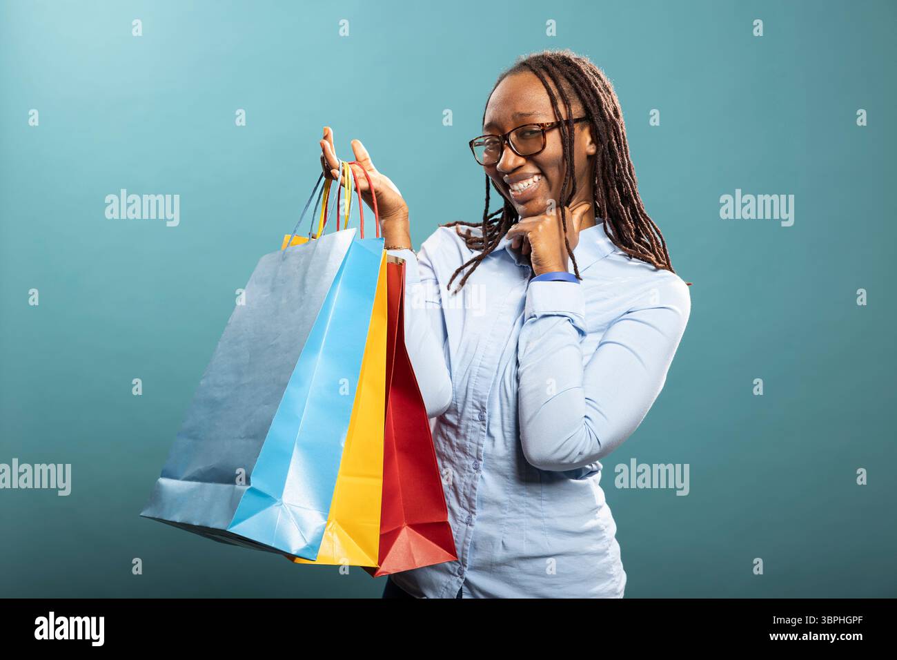 Joyful black female individual pleased with her purchase, holding ...