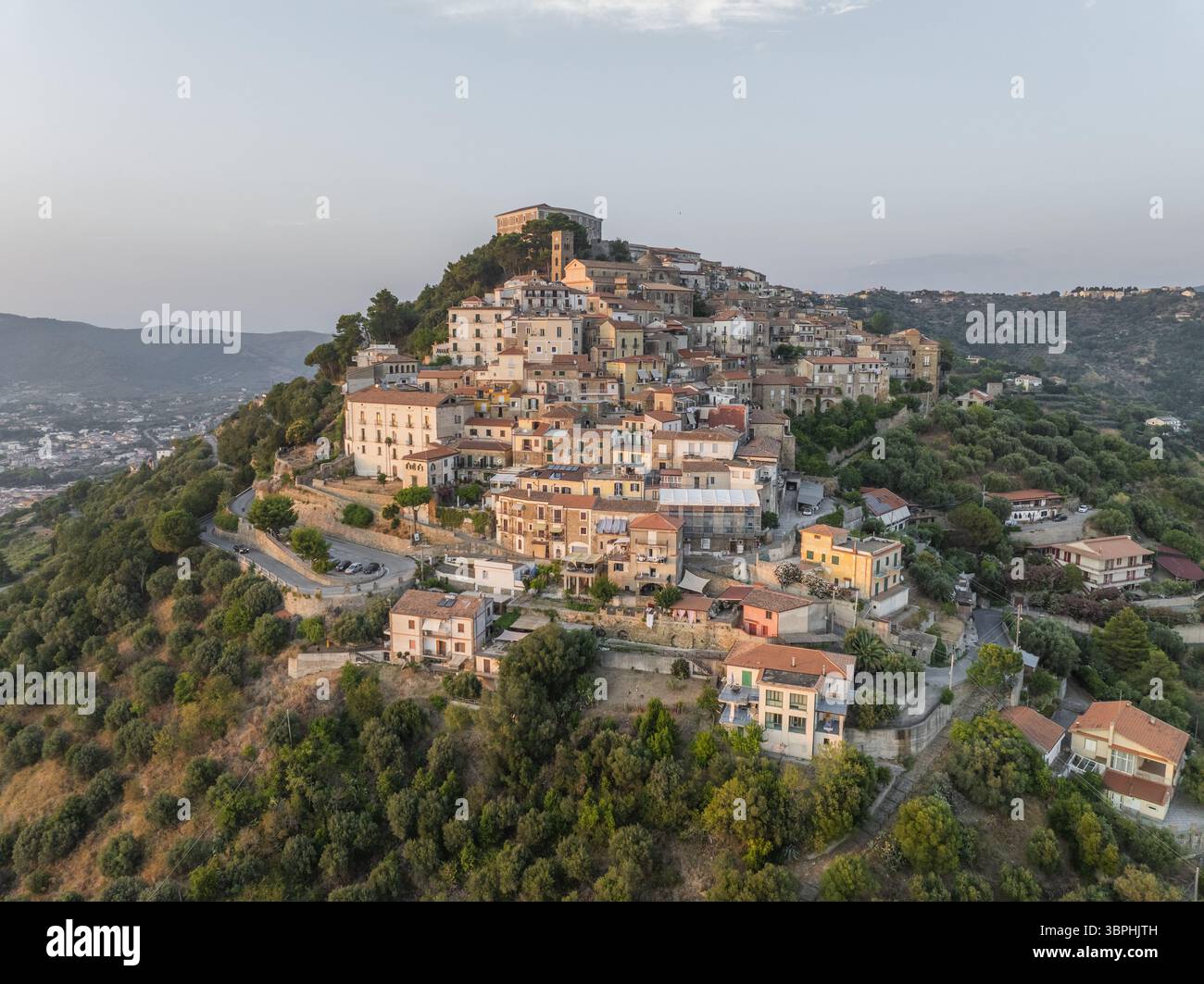 Aerial view of a hilltop village bathed in the warm glow of sunset ...