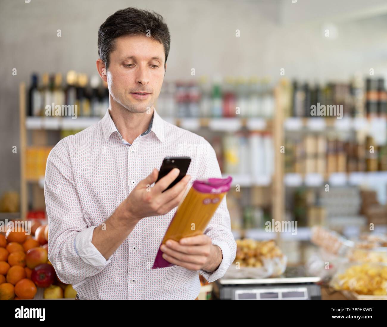 Adult man scanning qr code for pasta Stock Photo - Alamy