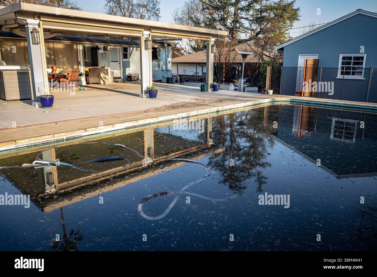 An Altadena home's in-ground pool filled with charred debris from the ...