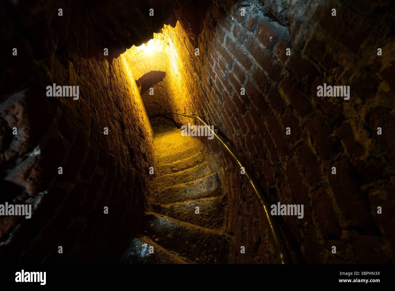 Arched narrow passage with spiral stair Stock Photo - Alamy