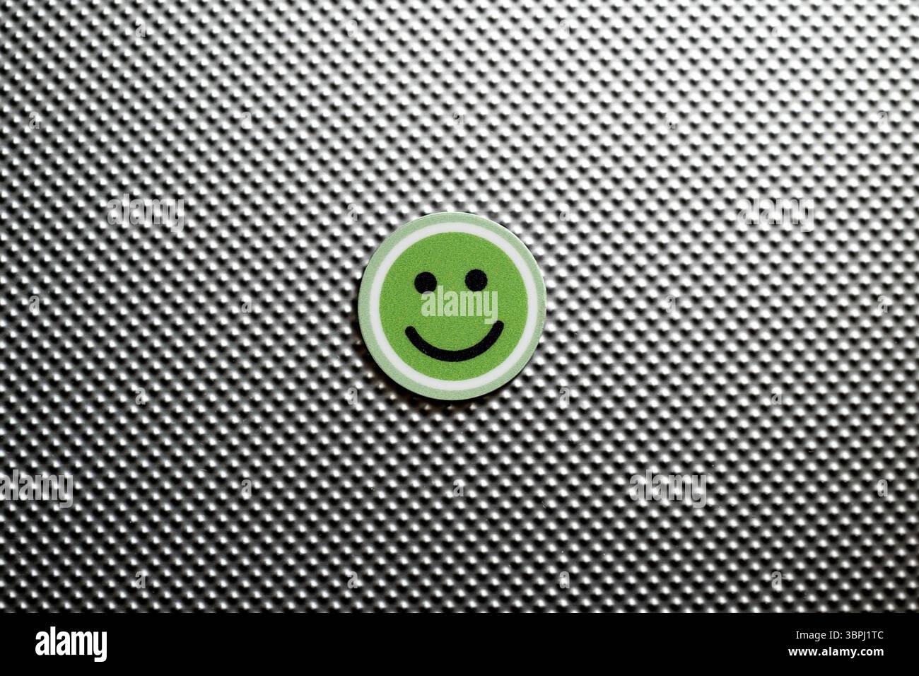 round emoji face in green color, representing happy emotions on a ...