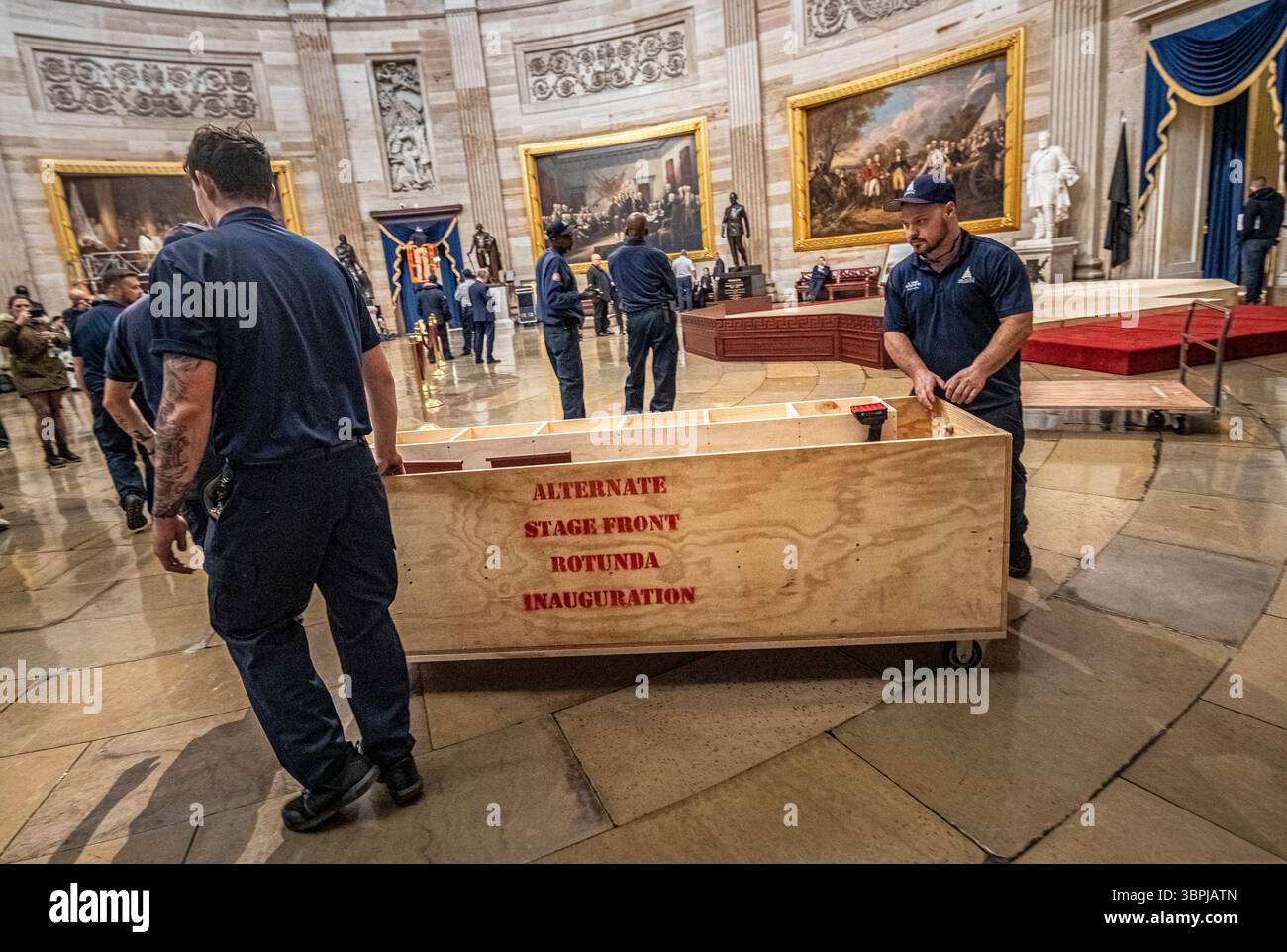 A stage is quickly assembled inside the Rotunda as cold weather forces ...