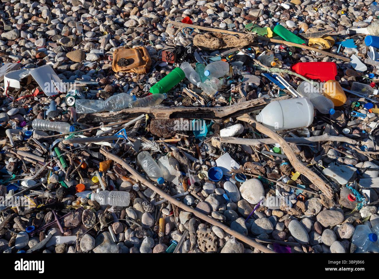 Plastic garbage polluting a pebble beach, highlighting environmental ...