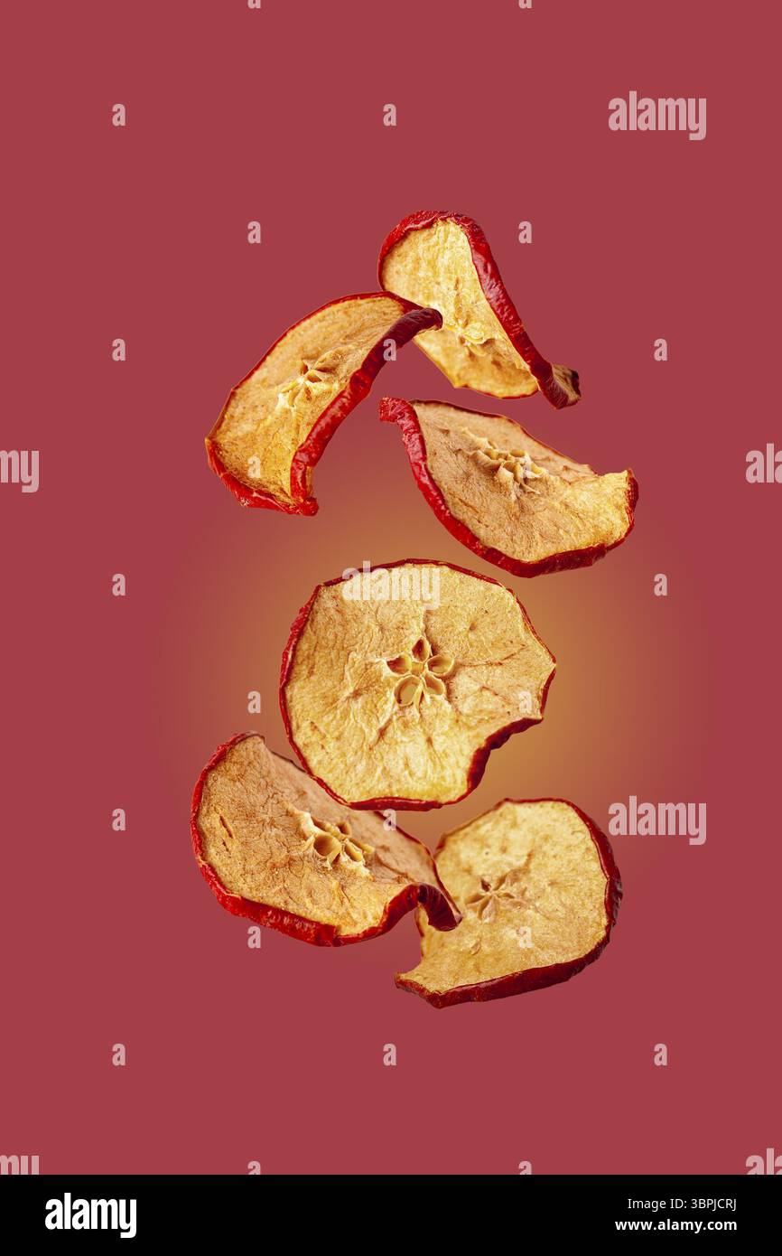 Dried apples flying on a red background Stock Photo - Alamy
