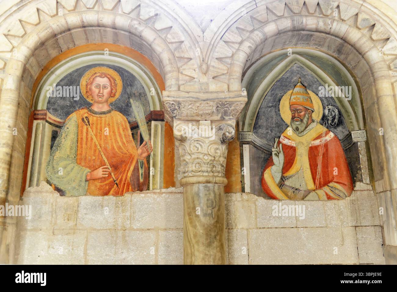 Two frescoes of figures of saints in an ancient room with ornate ...