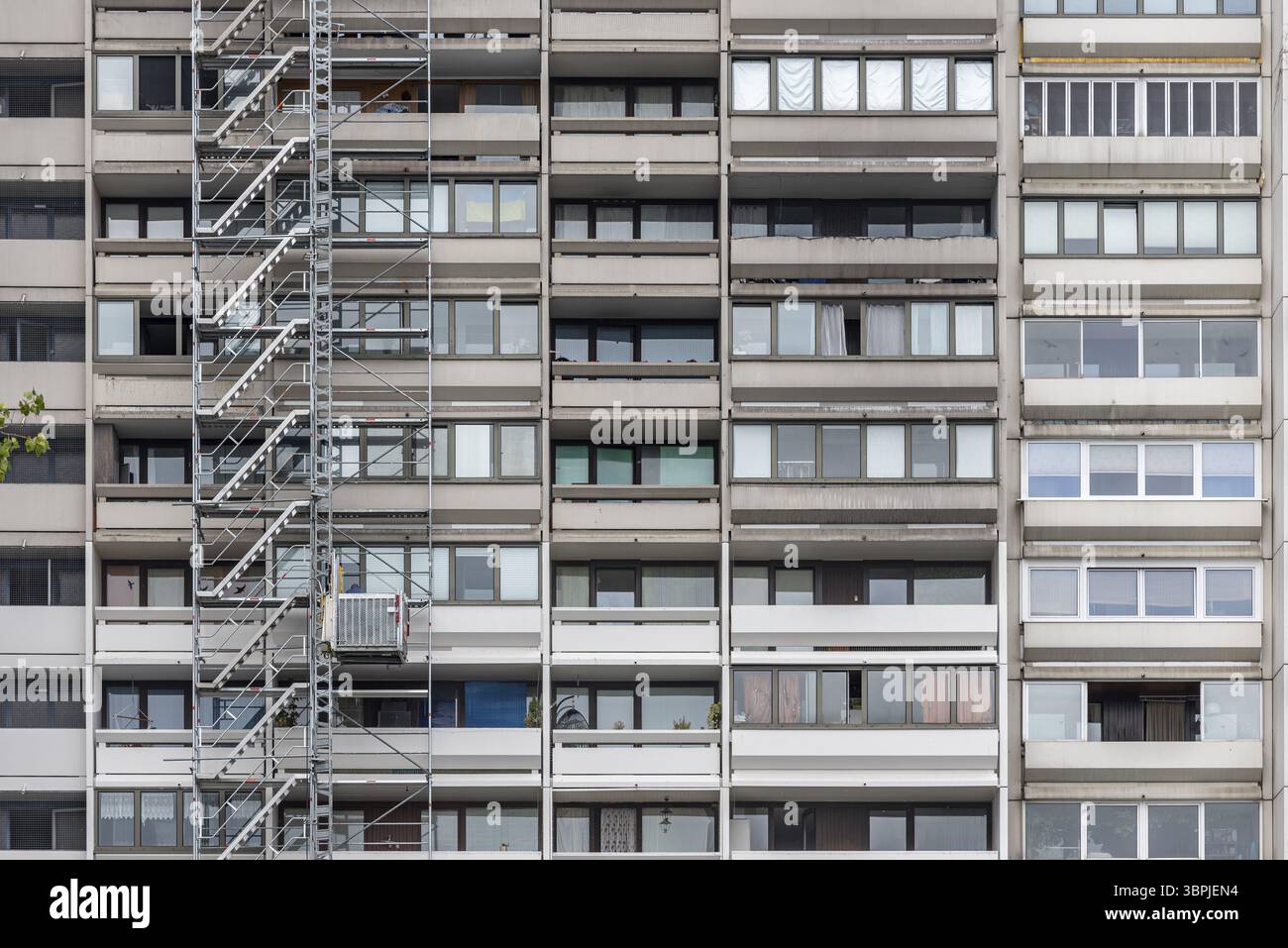 The grey facade of a high-rise residential building with balconies, an ...