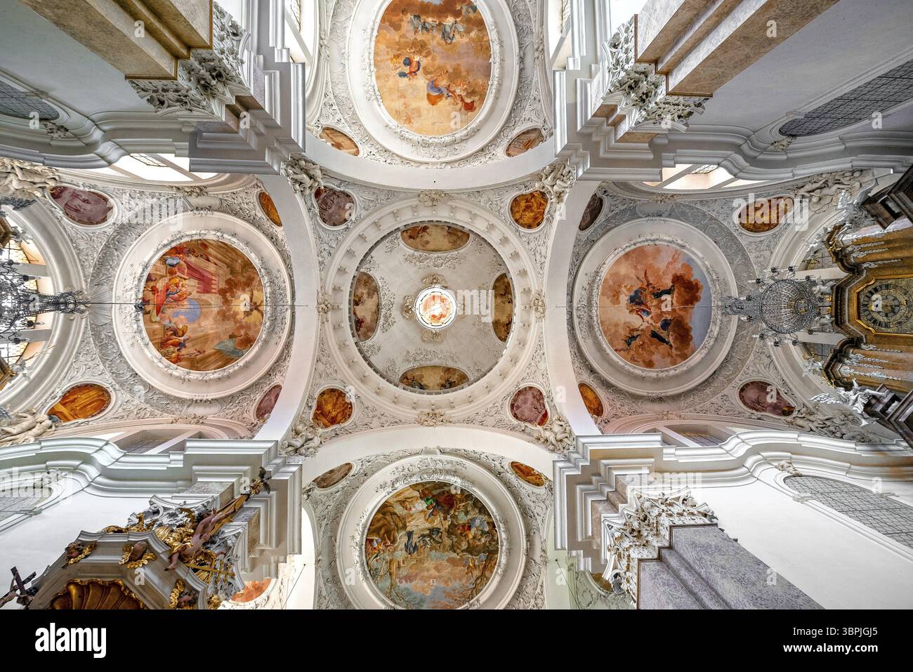 The baroque-style church ceiling with columns and colourful pictures ...