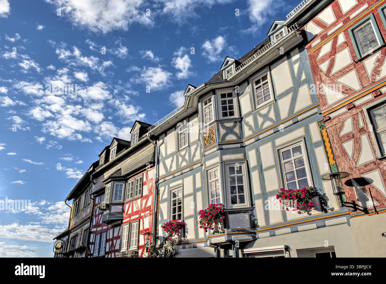 The facades of half-timbered houses in oblique view with blue sky and ...