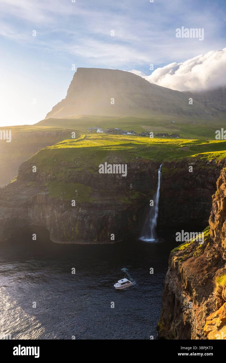 View of the Mulafossur waterfall with the small village of Gasadalur ...