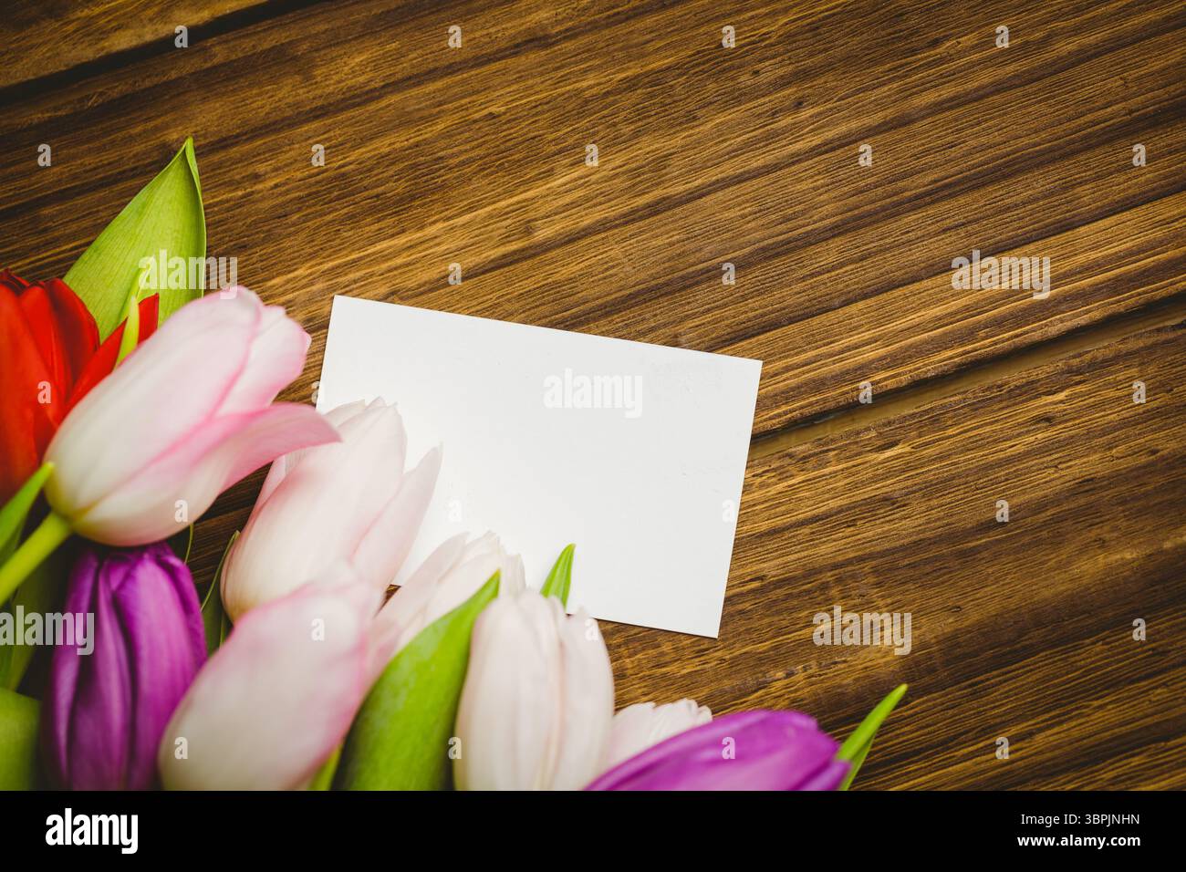 blank white rectangular card is lying atop wooden tabletop in flat-lay ...