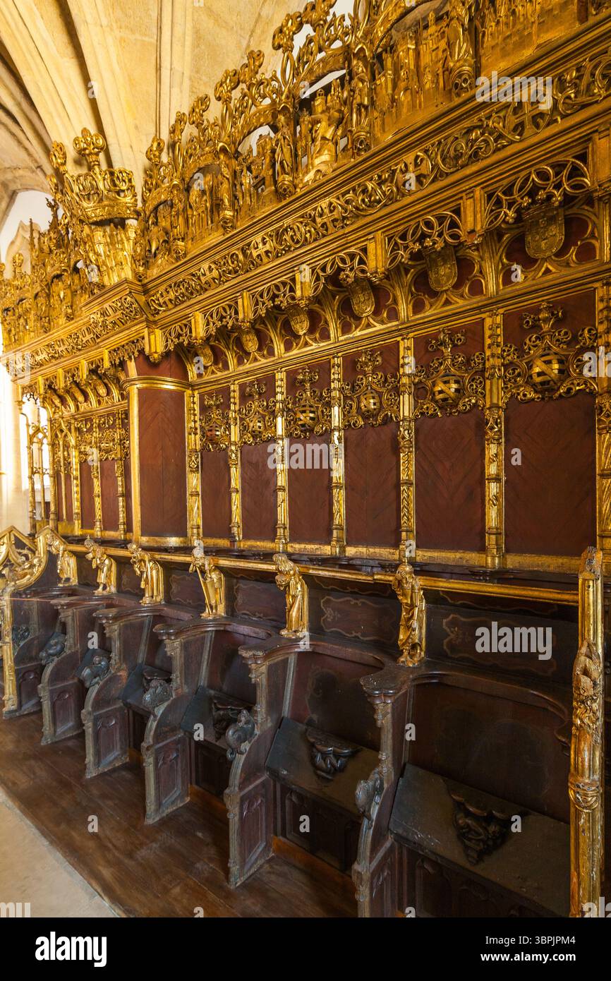 A grand interior featuring ornate wooden pews with rich red upholstery ...