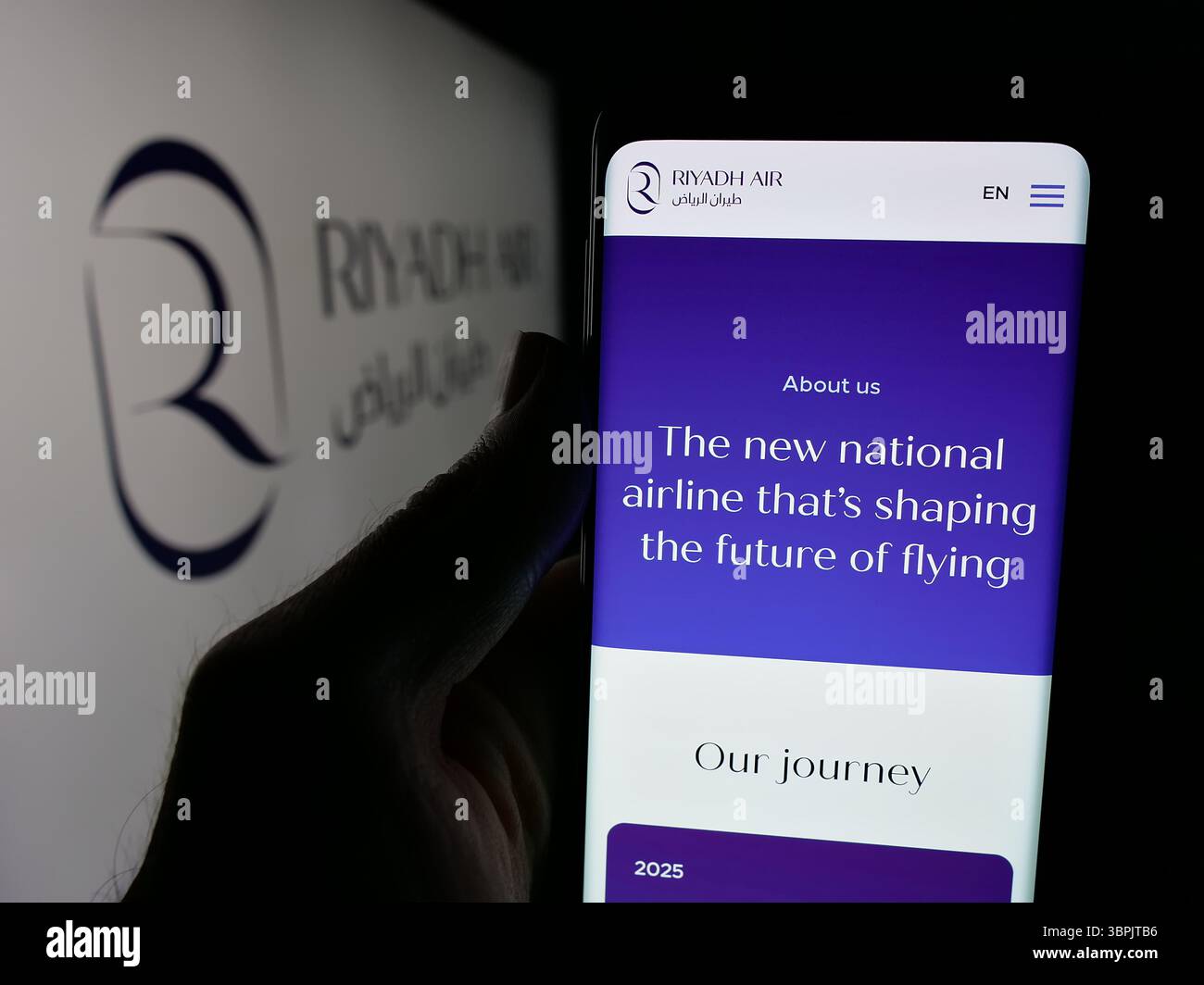 In this photo illustration, a person is holding a smartphone with the webpage of Saudi Arabian ...