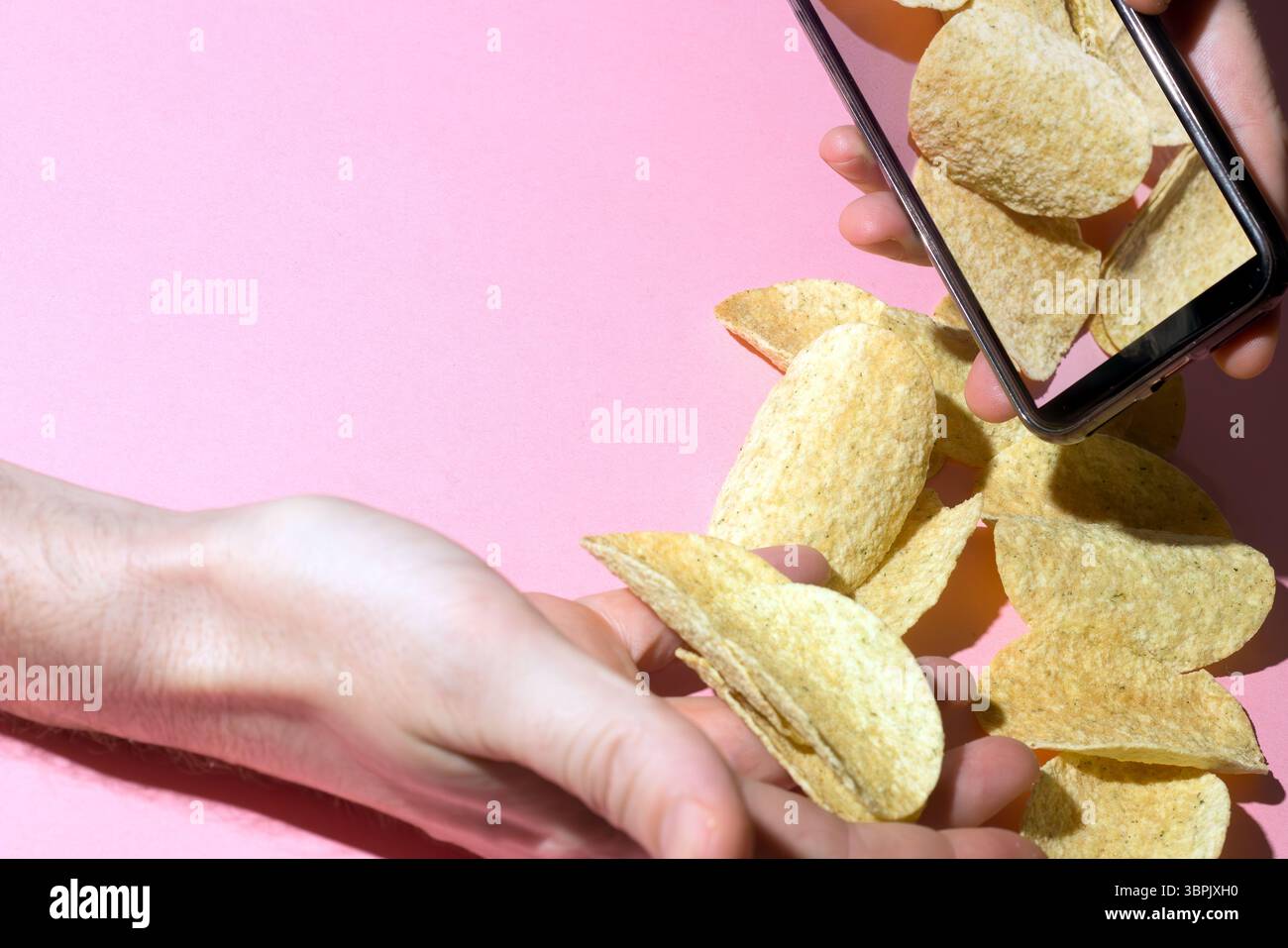 Potato Chips Dispensing from Smartphone into Hands Stock Photo - Alamy