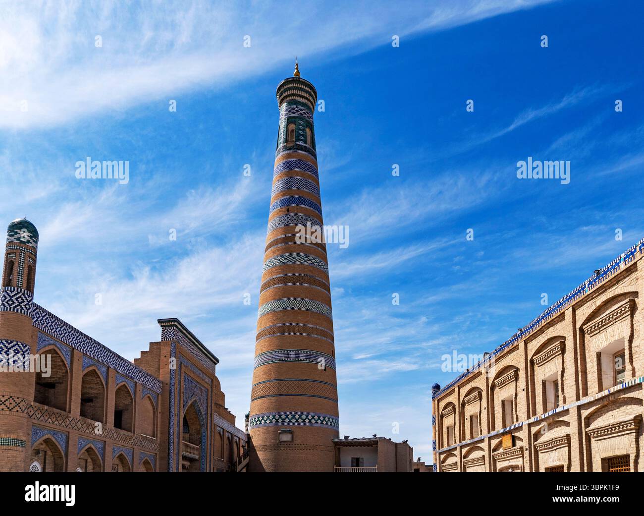 A tall, intricately designed minaret with colorful patterns, surrounded ...