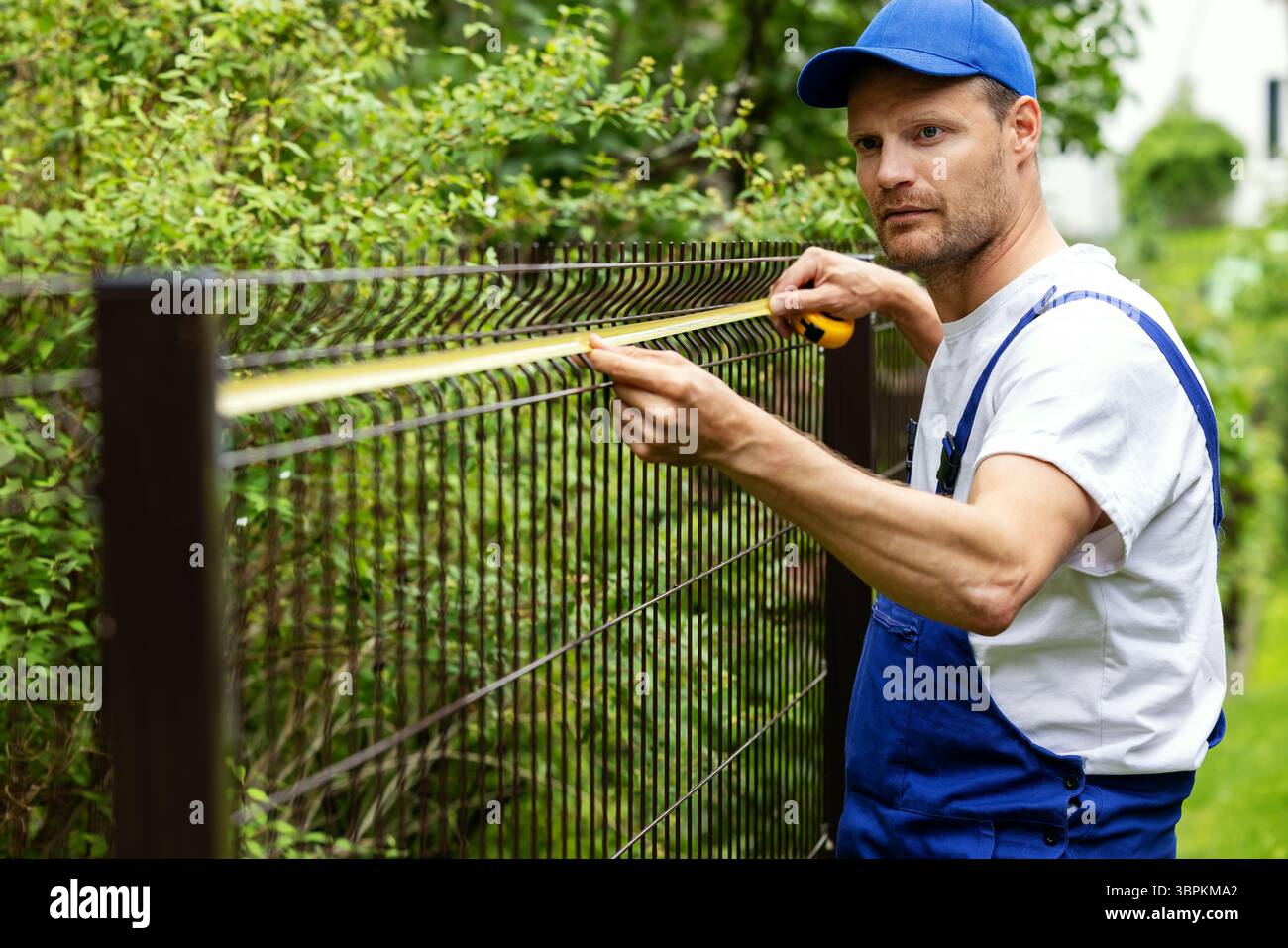 Fencing services worker taking measurements hi-res stock photography ...