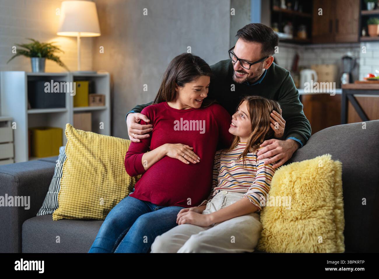Happy parents, teen daughter having pleasant conversation, laughing ...