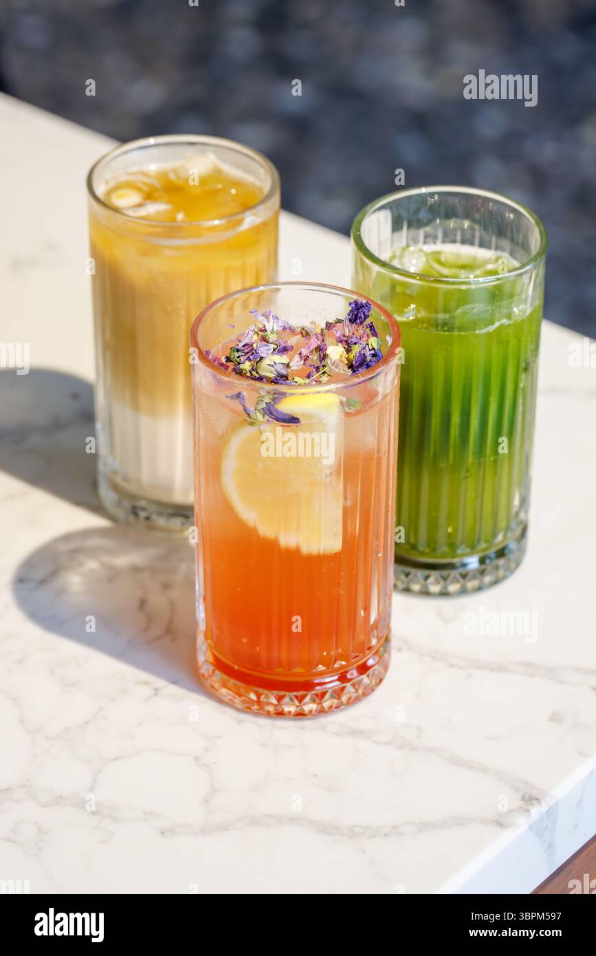Assorted summer lemonades in glass jars with fresh fruits, ice, and colorful garnishes Stock ...