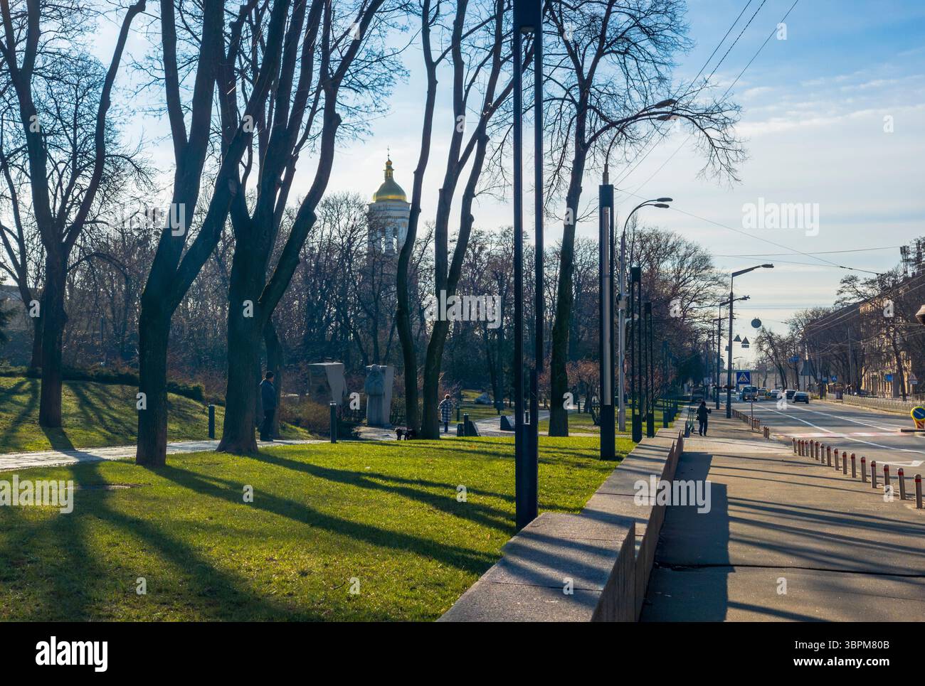 A sunny spring day in Kyiv showcases a tree-lined street with lush ...
