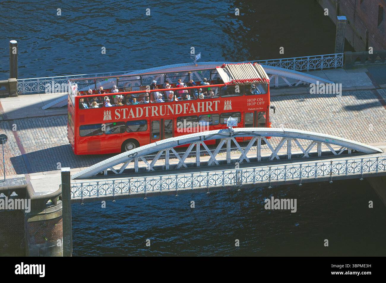 red open double-decker bus on a bridge in the Speicherstadt, city tour ...