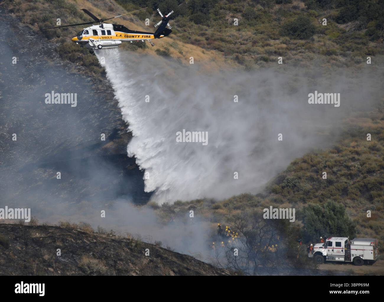 Fire helicopters make water drops as firefighters battle a fast ...