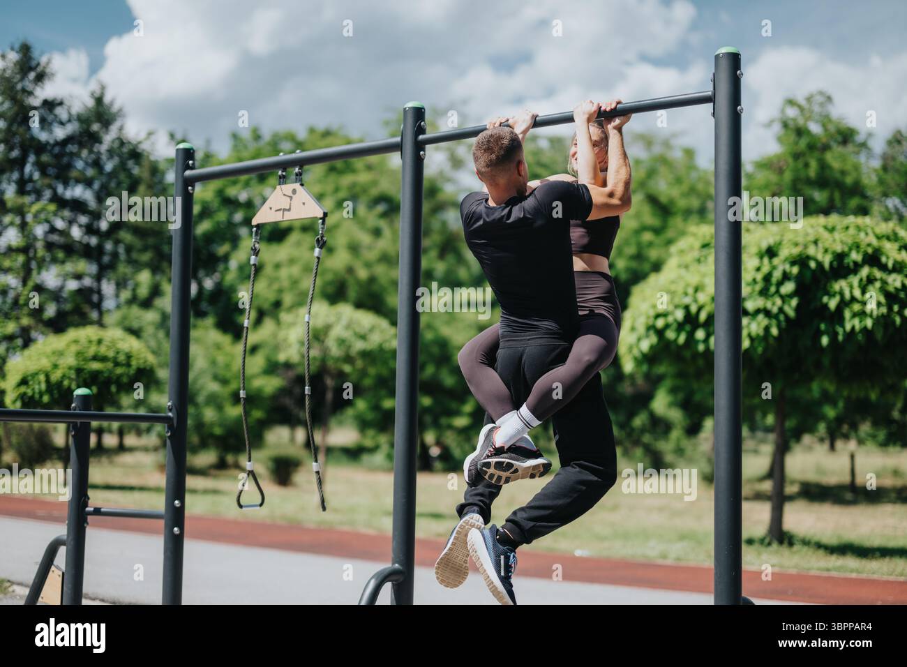 Couple Exercising Together on Pull-Up Bar in an Outdoor Park Setting ...