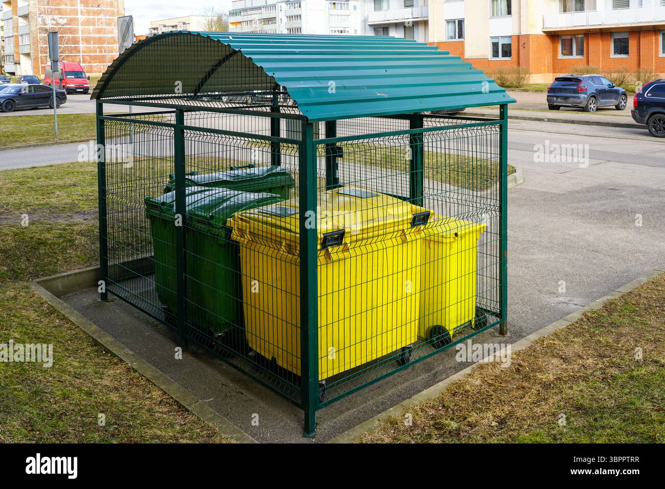 Recycling station with yellow and green bins secured under a metal ...