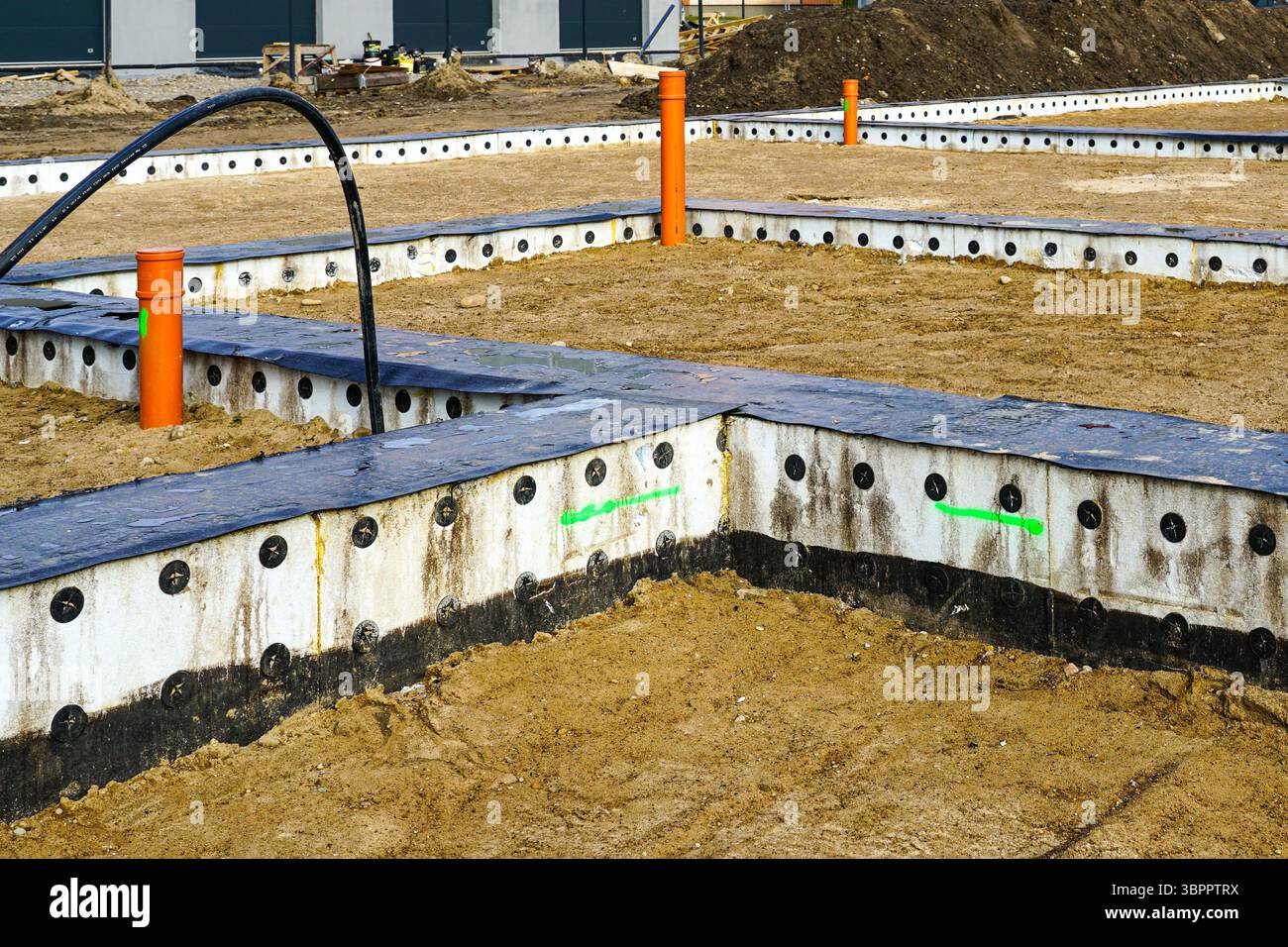 Concrete strip foundation with utility piping and insulation system at ...