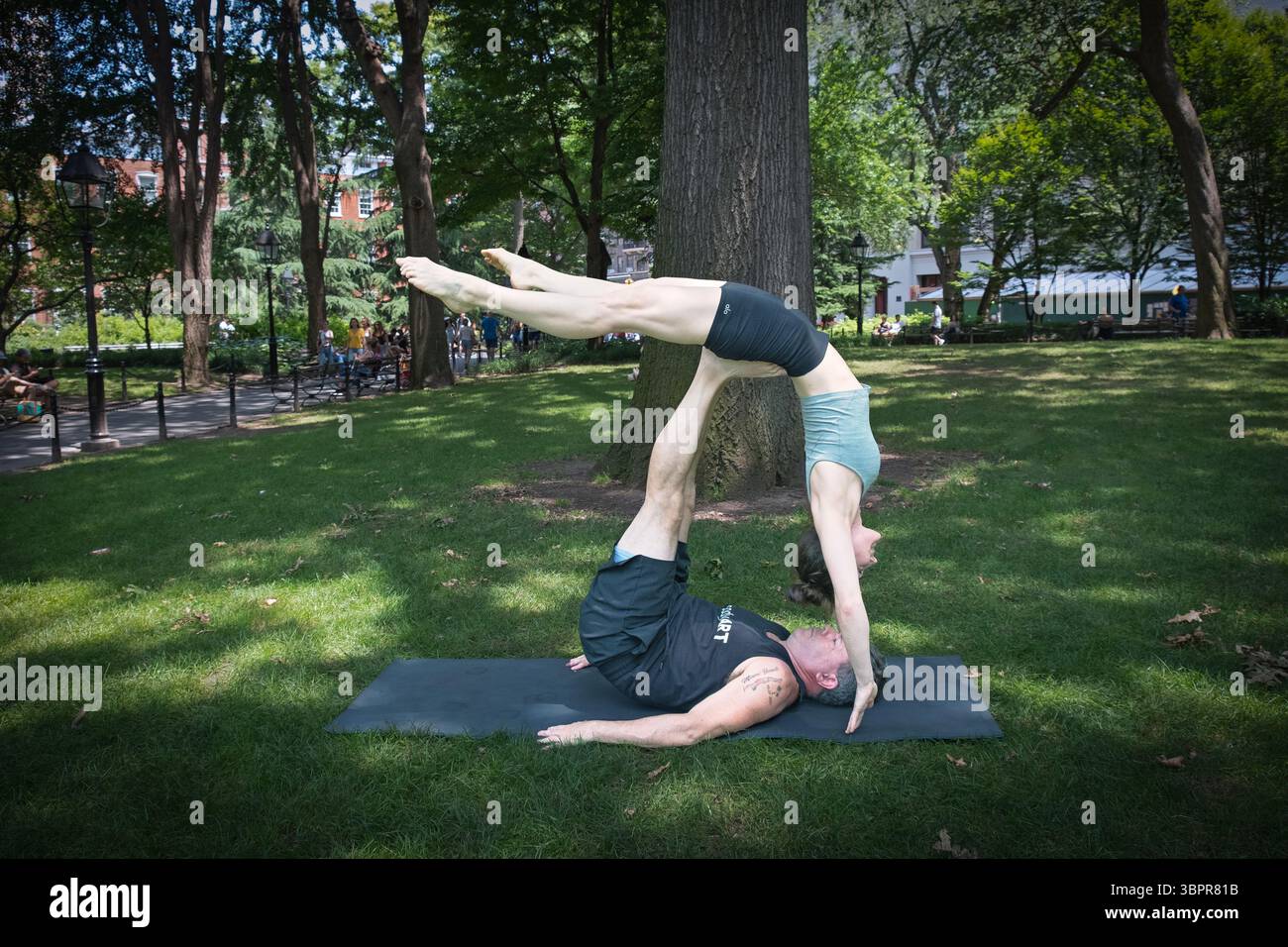 A graceful attractive lady performs Acroyoga, a practice that combines ...
