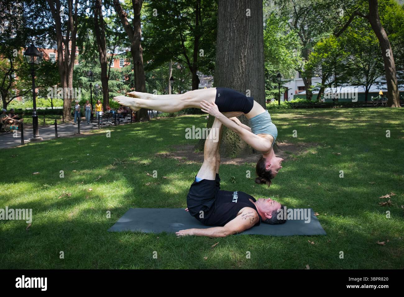 A graceful attractive lady performs Acroyoga, a practice that combines ...