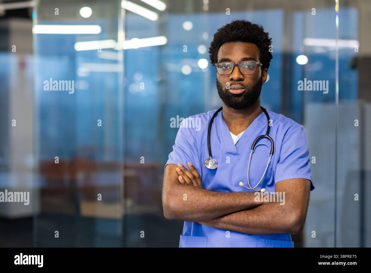A doctor wearing a stethoscope and eyeglasses poses with folded arms in ...