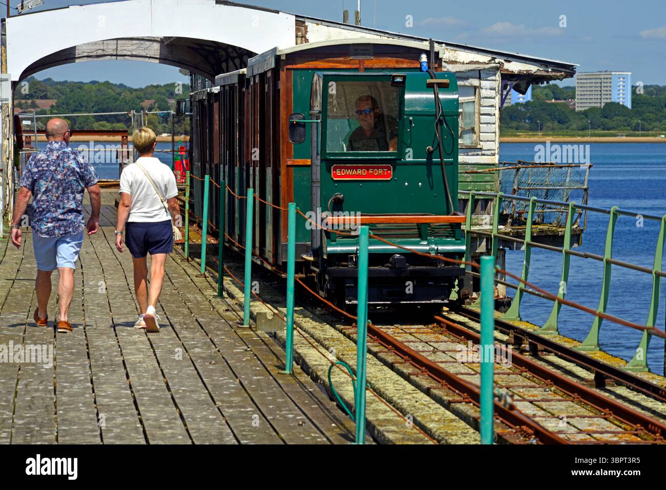 Two holidaymakers stroll past the Hythe Pier Electric train as it makes ...