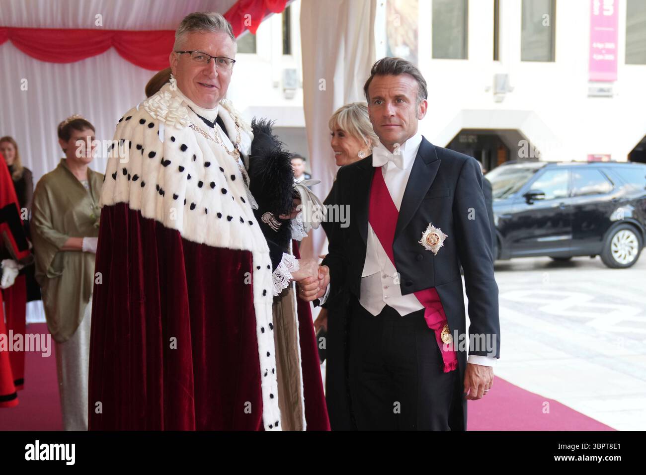 French President Emmanuel Macron, right, is greeted by the Lord Mayor ...