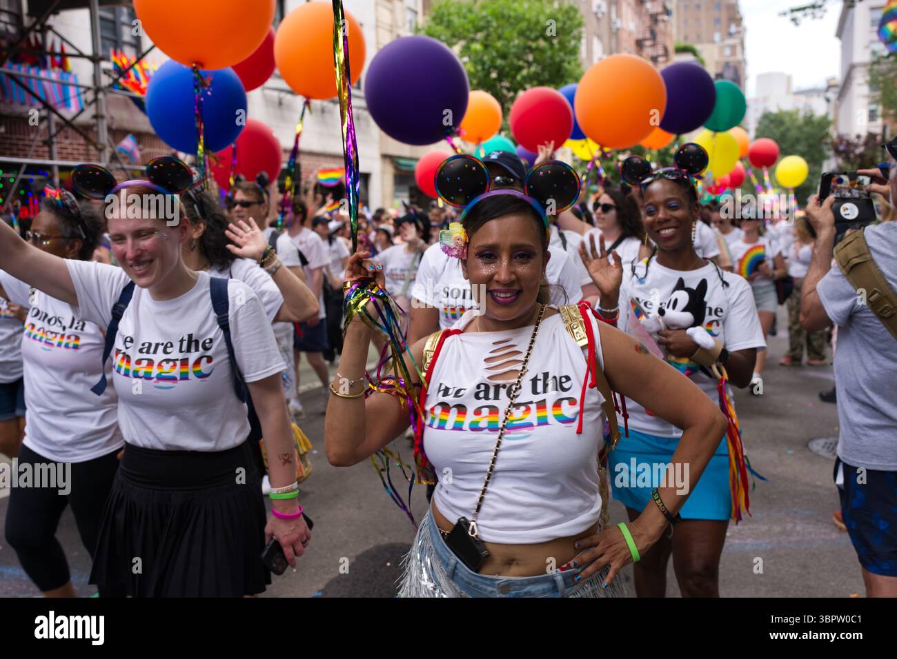 A group of people, predominantly women, march in a parade. Many wear ...