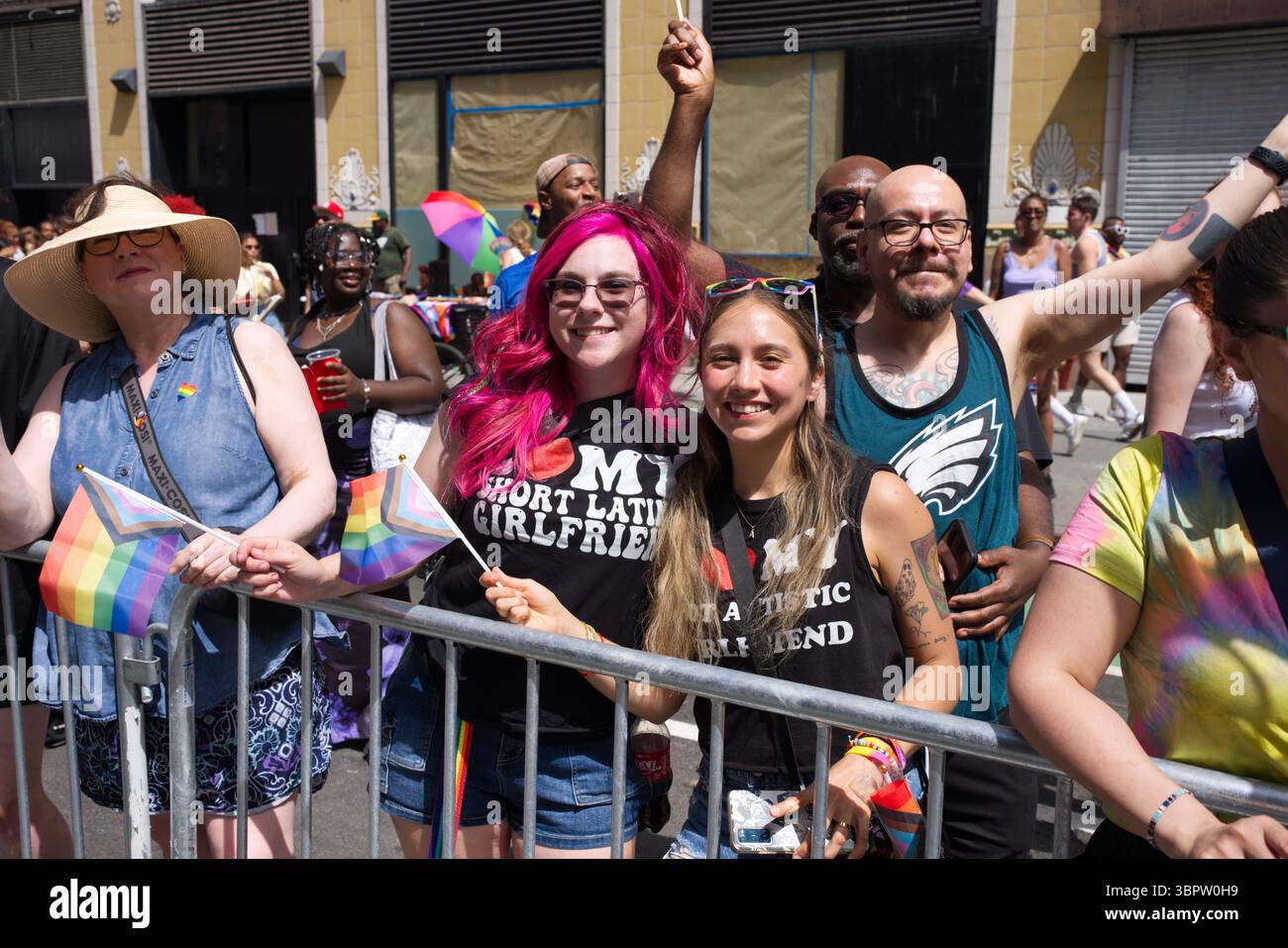 A group of people, predominantly women, at a Pride parade, hold rainbow ...