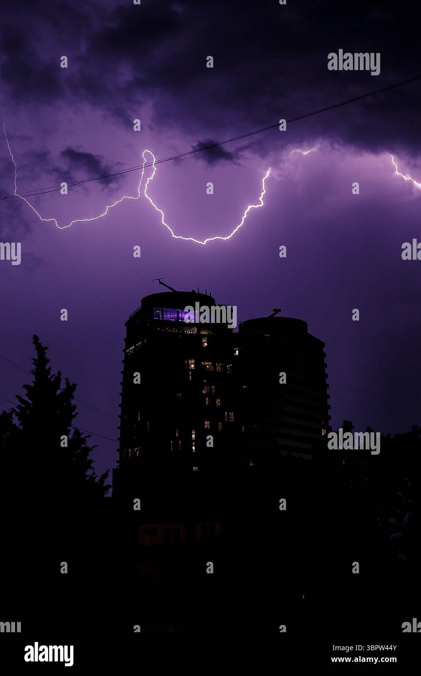 Night thunderstorm over Tbilisi’s twin towers—lightning strikes illuminate the skyline in a ...