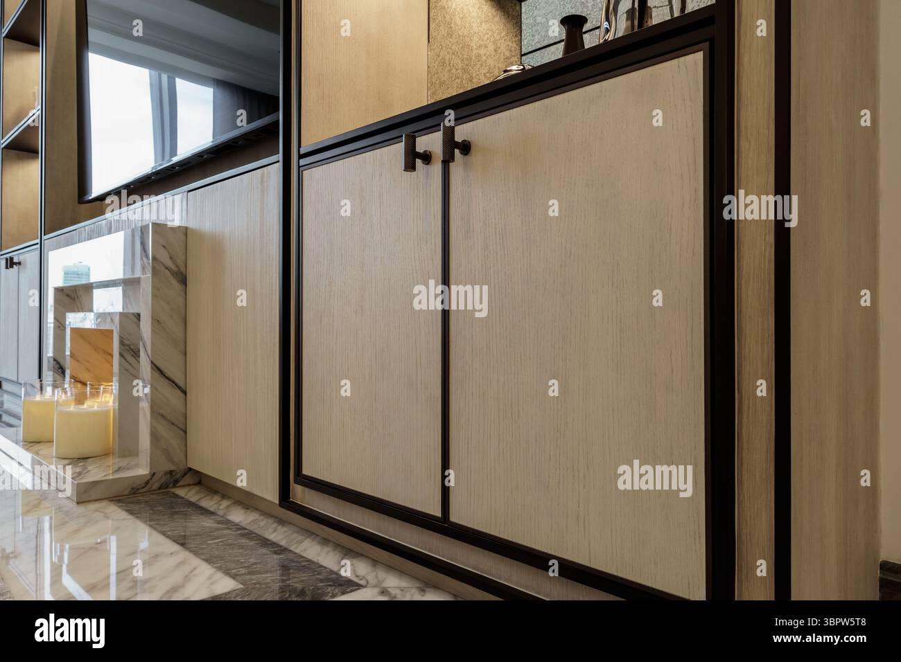 Detail of a custom built-in cabinet featuring light wood grain doors ...