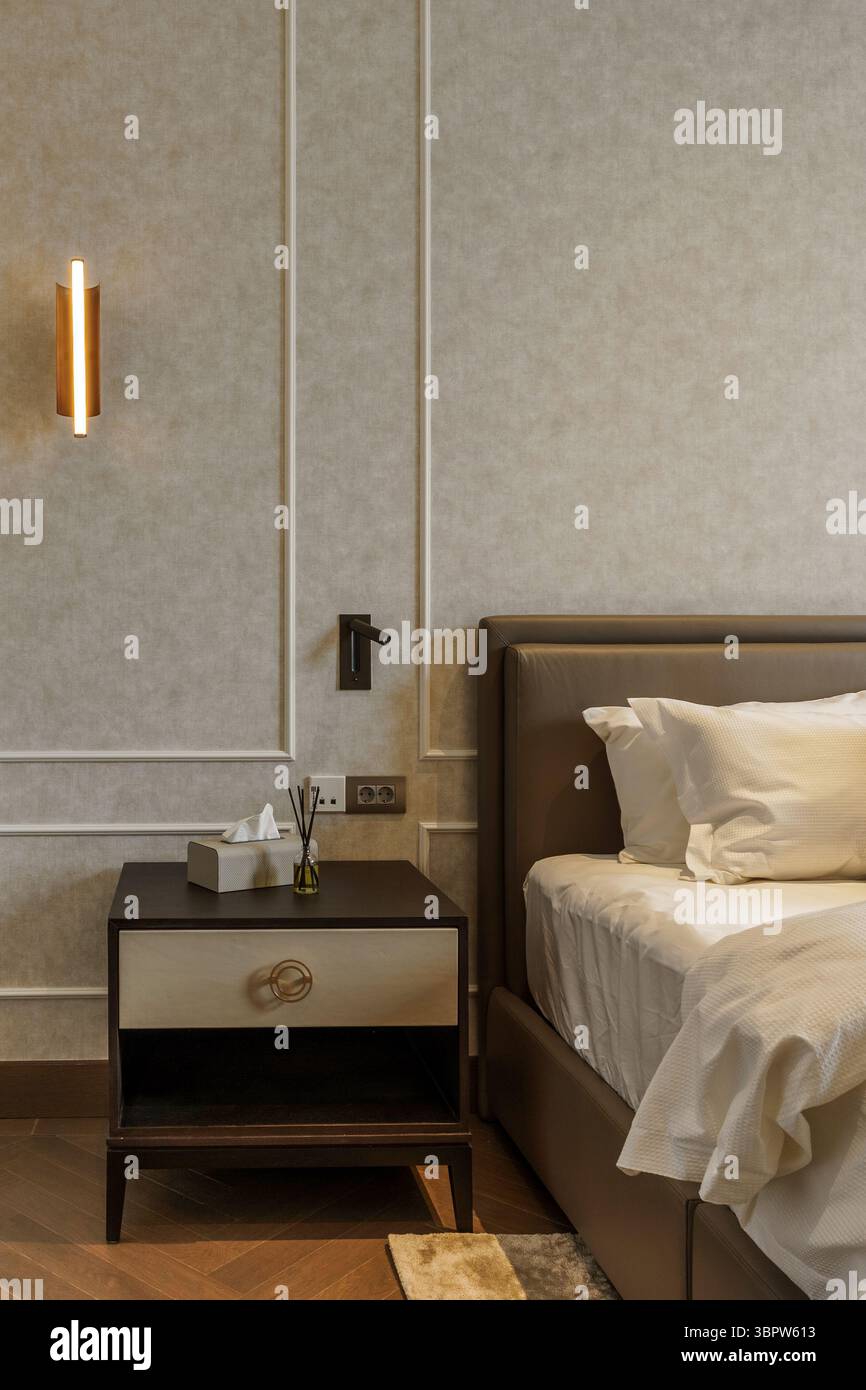 Elegant bedroom nightstand with a modern wall sconce and reading light ...