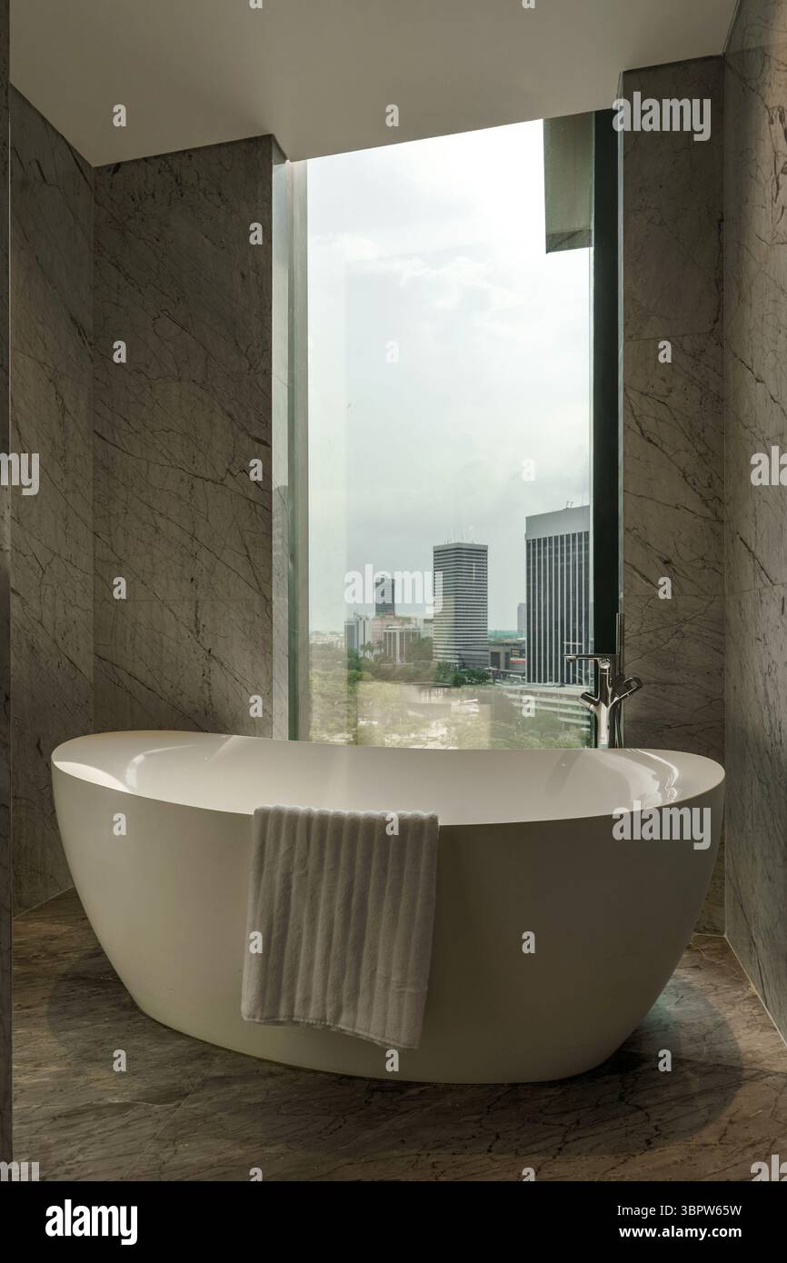 Minimalist freestanding white bathtub in a luxurious grey marble ...