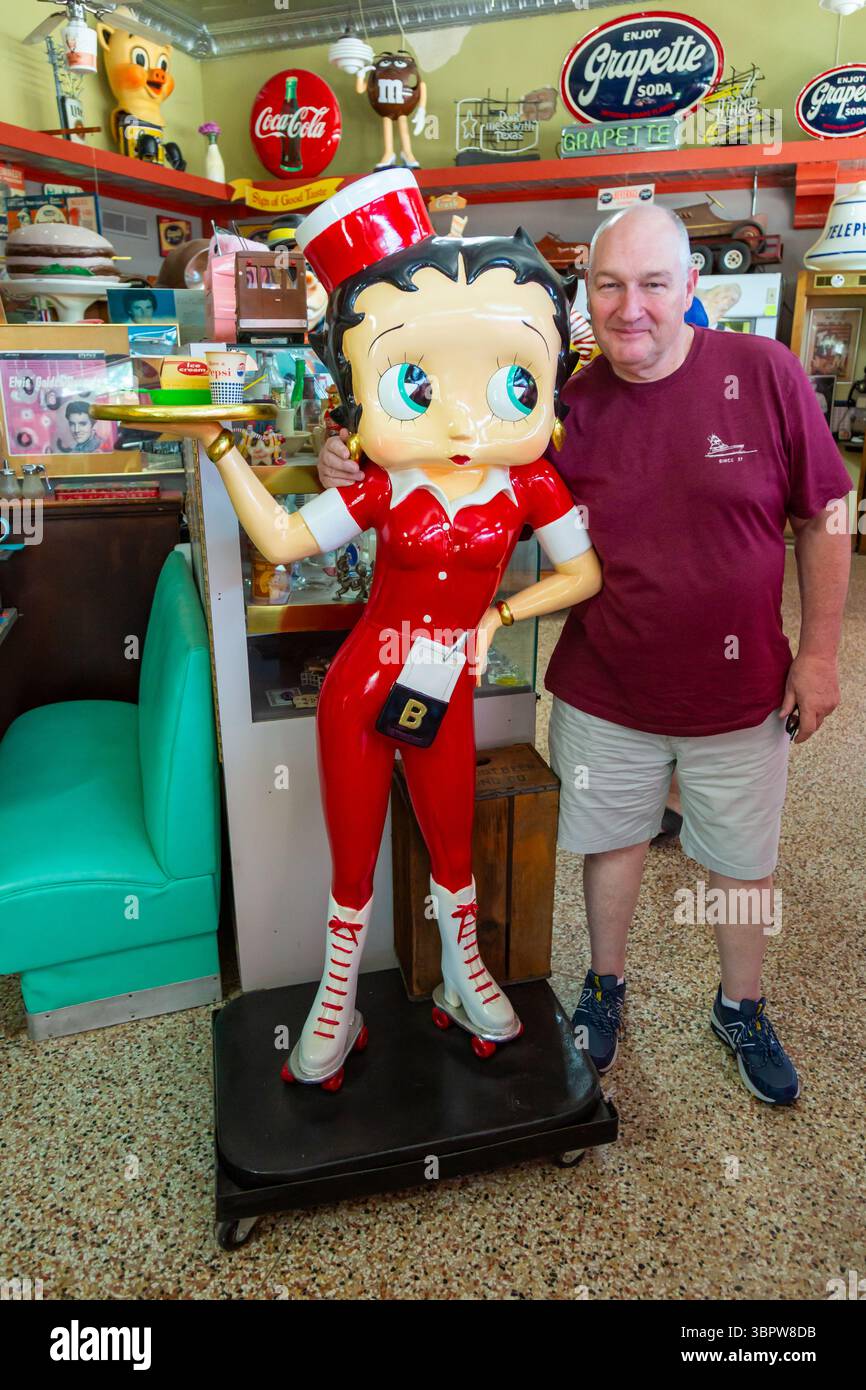 A man poses with a Betty Boop car hop figure at the Roadside America ...