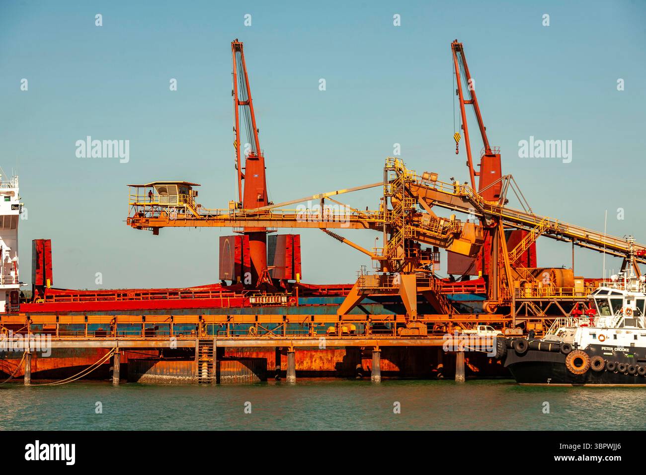 man back standing foot up on rail conveyer bridge bauxite loading ship ...