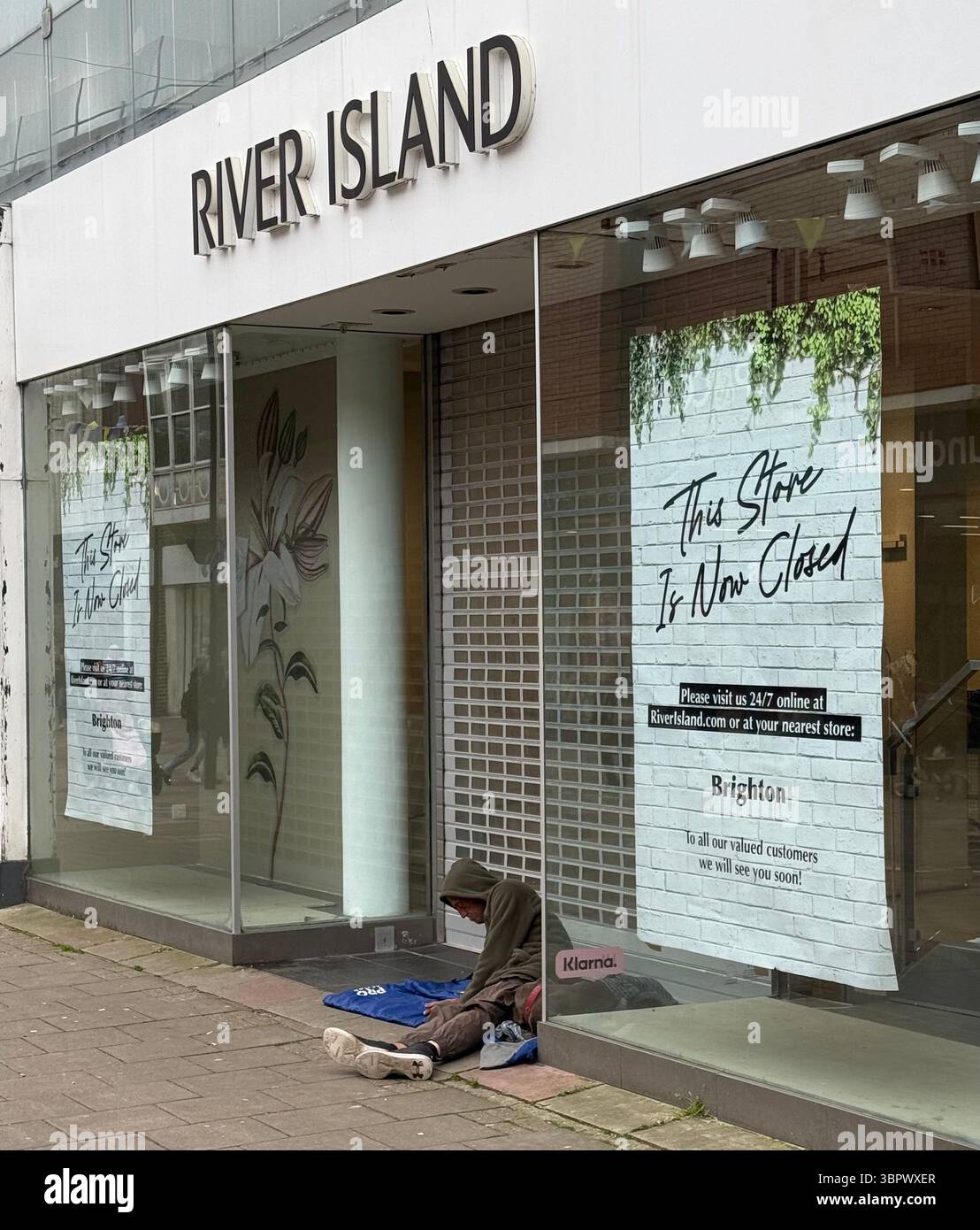 A homeless person in a doorway of a closed down high street store Stock ...