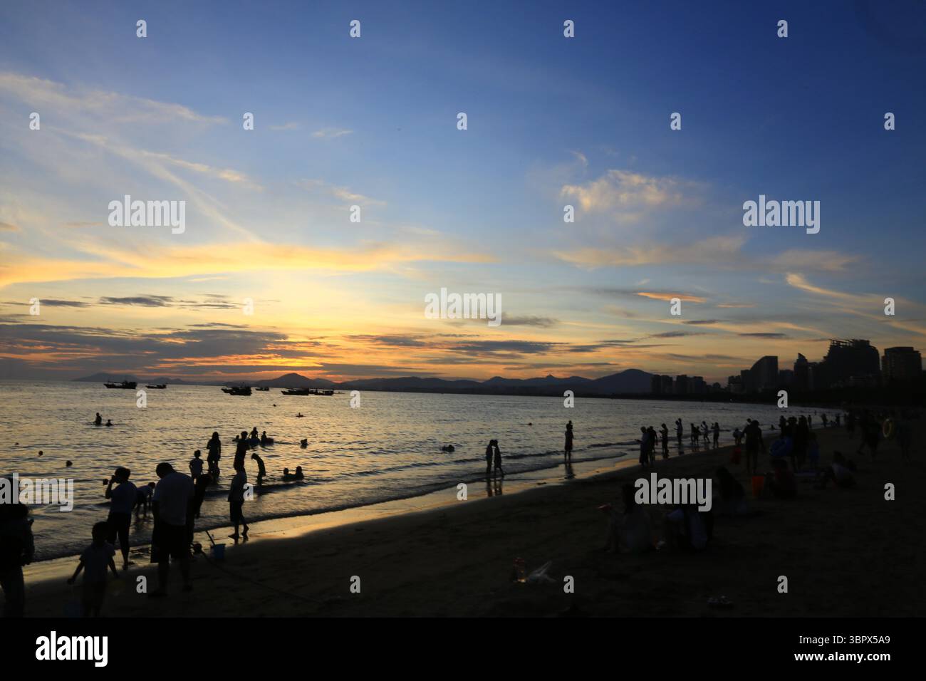 Tourists play at the seaside in Sanya City, southernmost China's Hainan ...